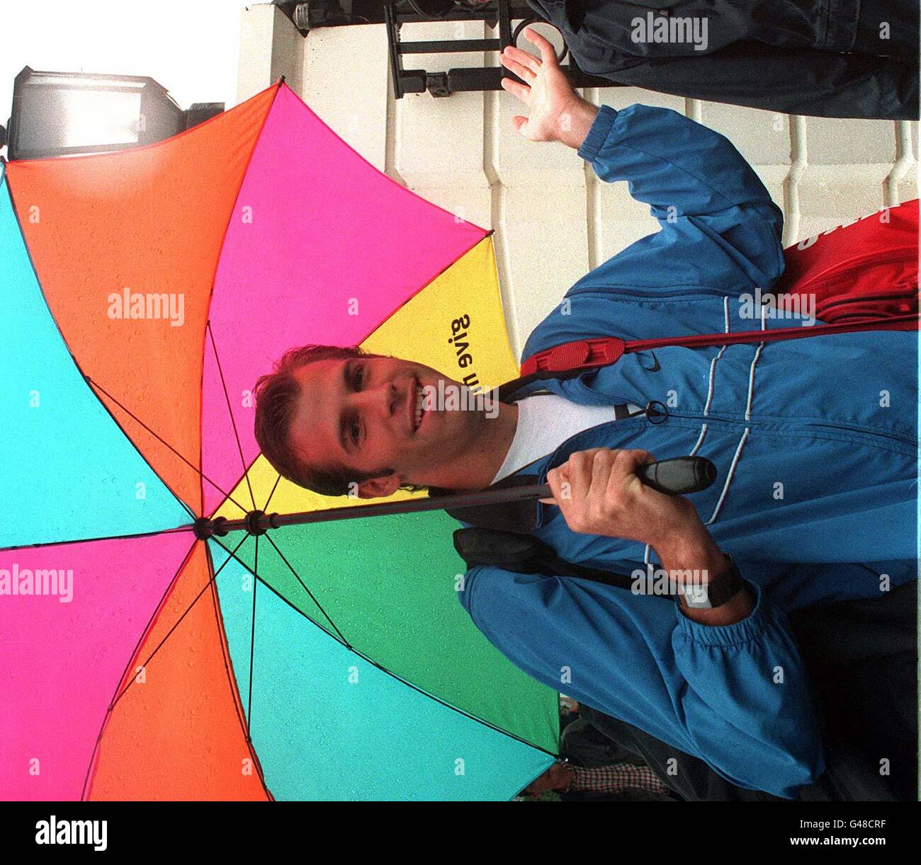 Hoping for the rain to stop. Britain's Greg Rusedski arrives at wet ...