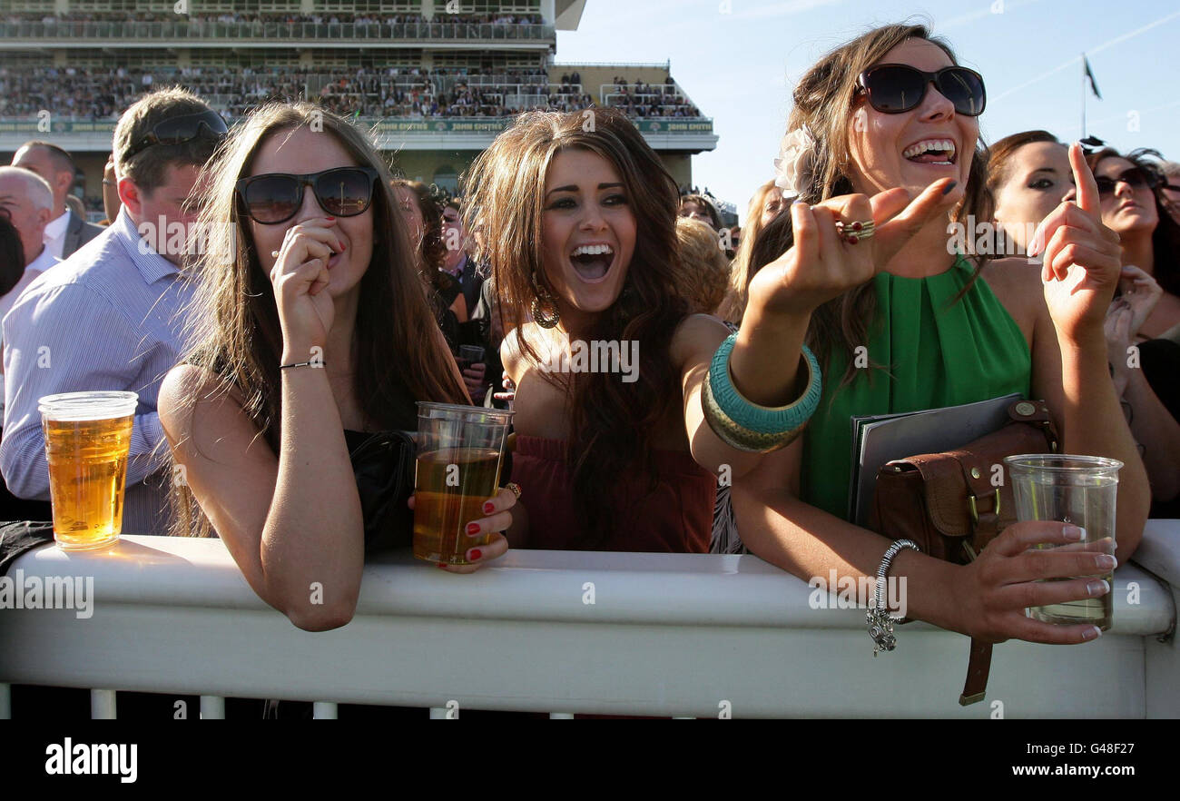 Female racegoers react during one of the races at Ladies' Day during ...