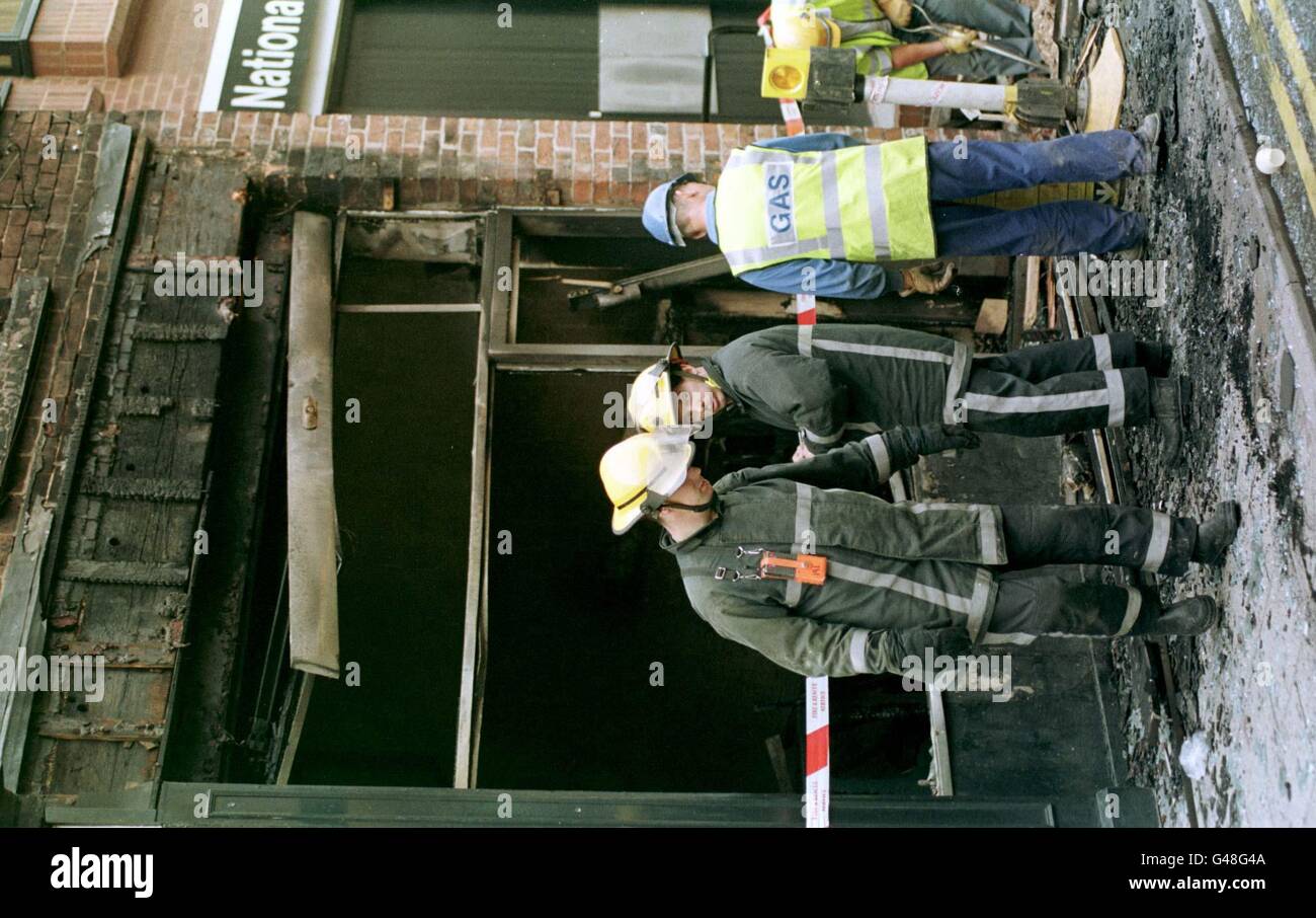 Fire officers examine the shell of the dry cleaners in Cheadle ,Staffs ...