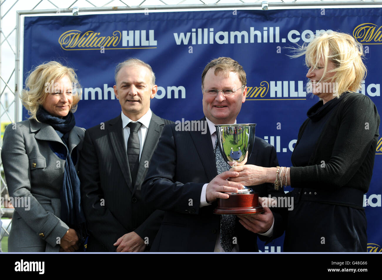 Winning trainer Michael Dods receives the trophy after Sweet Lightning ...