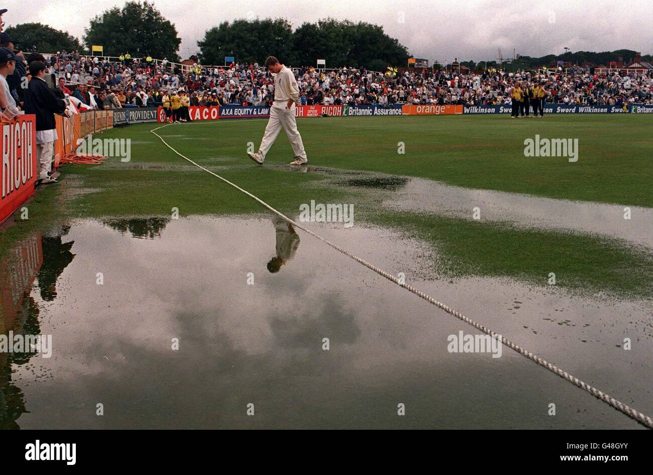 England Cricket Captain Mike Atherton walks across a rain flooded ...