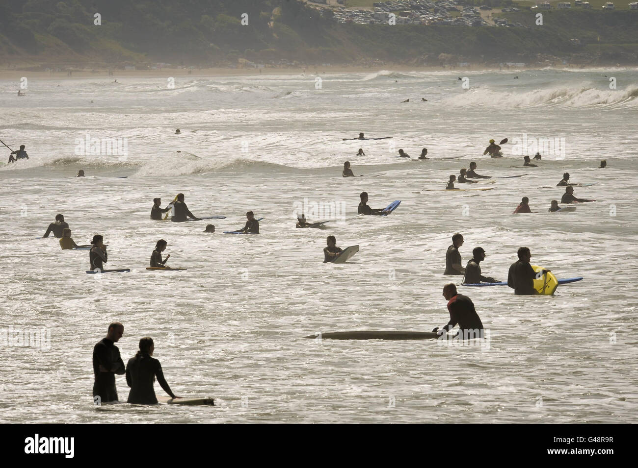 Surfers, bodyboarders and swimmers enjoy the waves at Woolacombe beach ...