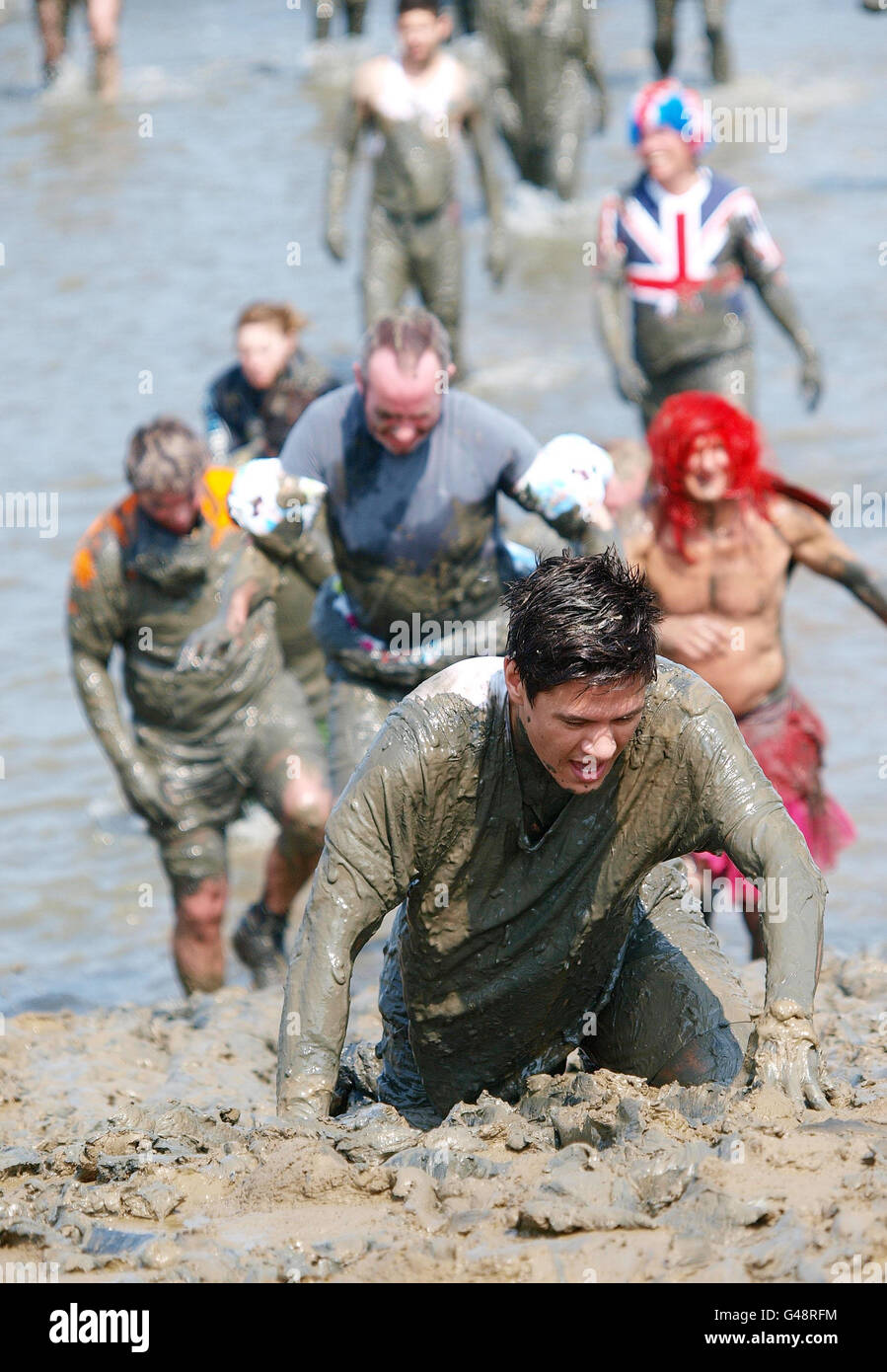 Competitors struggle in the mud during the annual Maldon Mud Race on ...