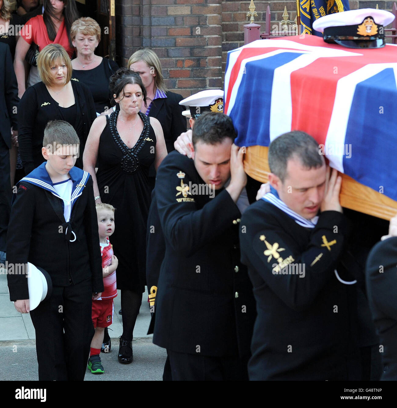 The coffin of Lieutenant Commander Ian Molyneux is followed by wife ...