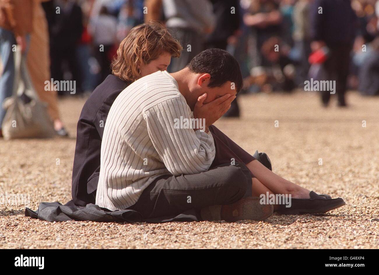 Mourners wipe tears Stock Photo - Alamy