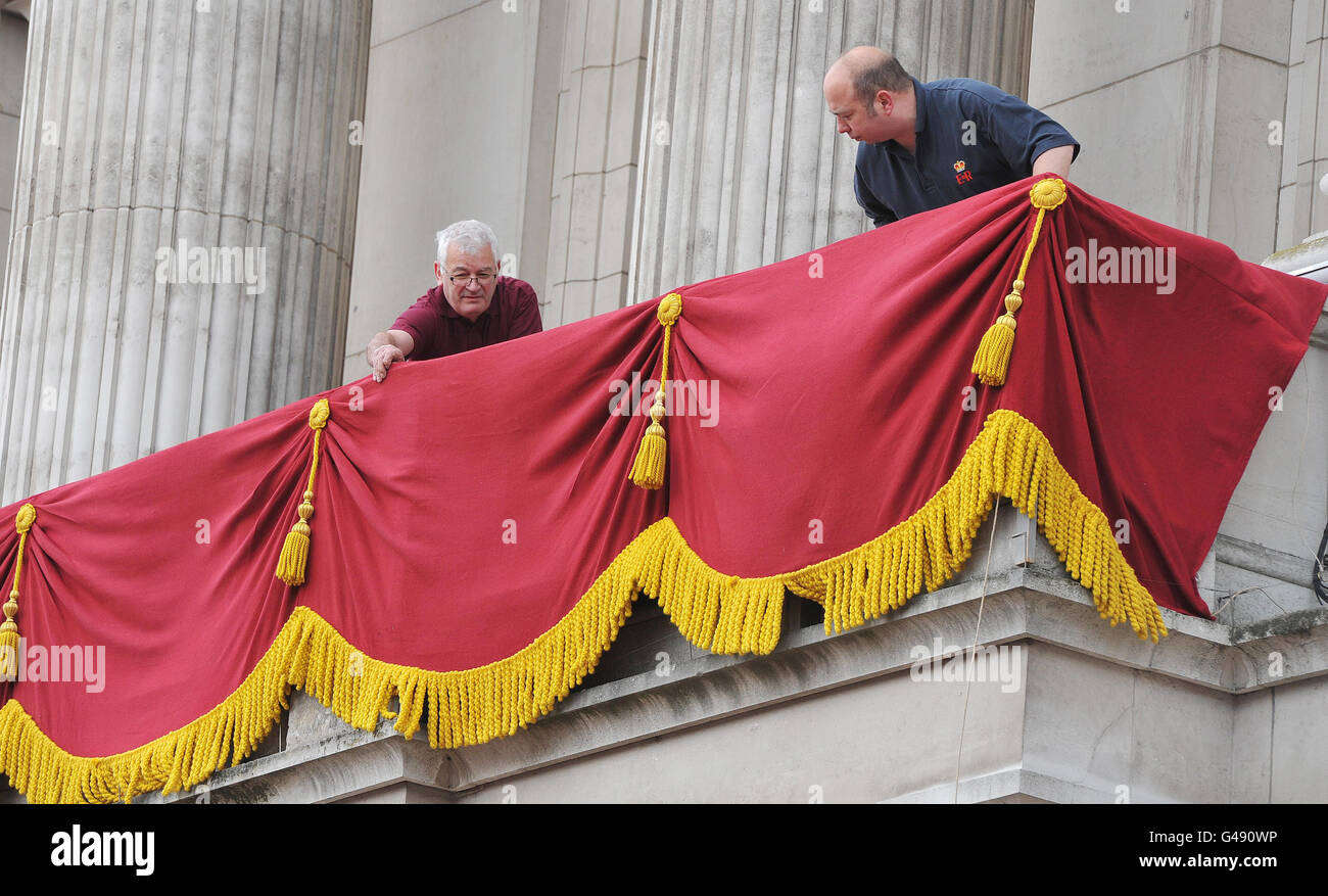 Staff dress the balcony at Buckingham Palace in central London, from ...