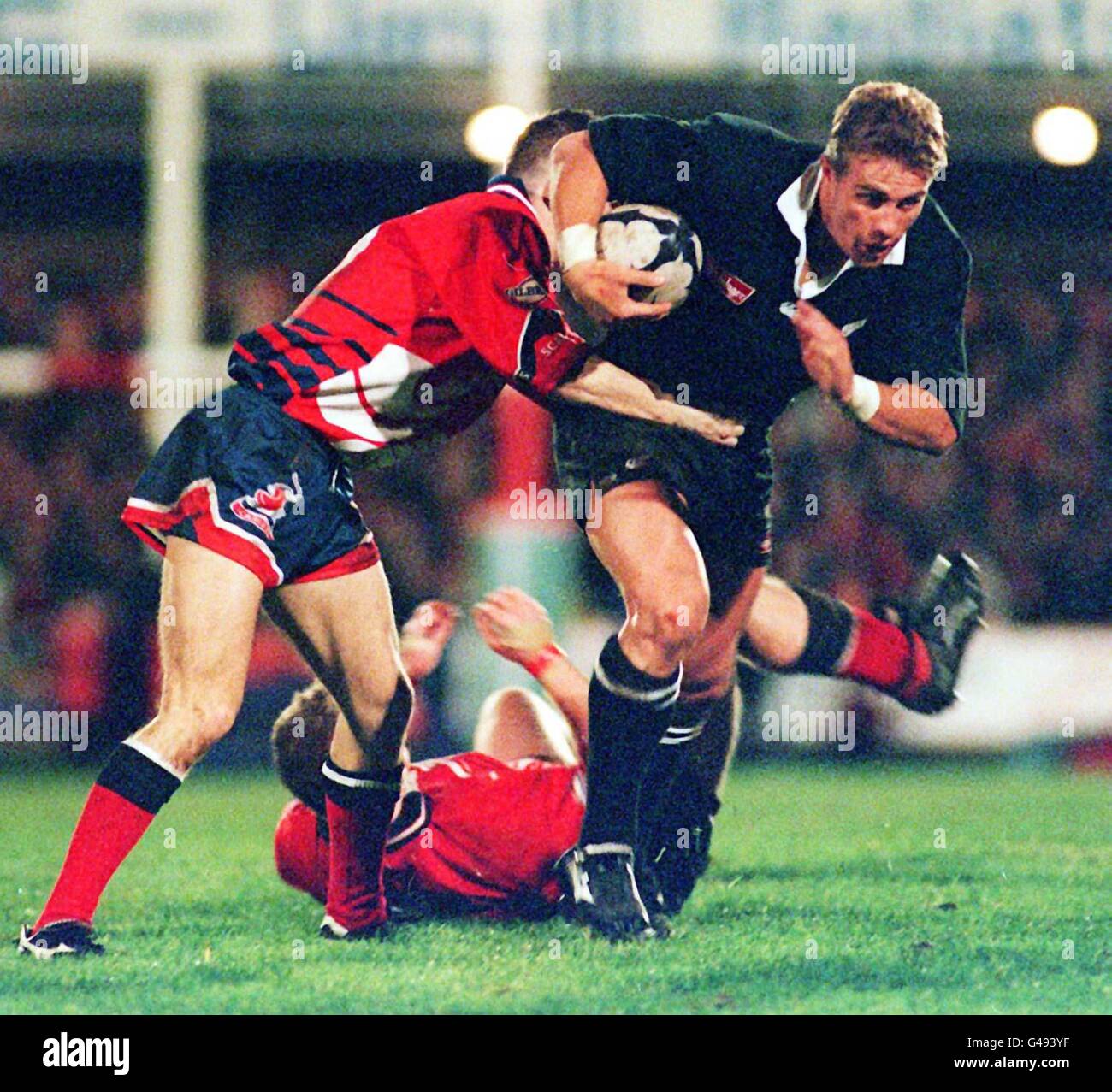 New Zealand's player Andrew Blowers (right) charges through Llanelli ...