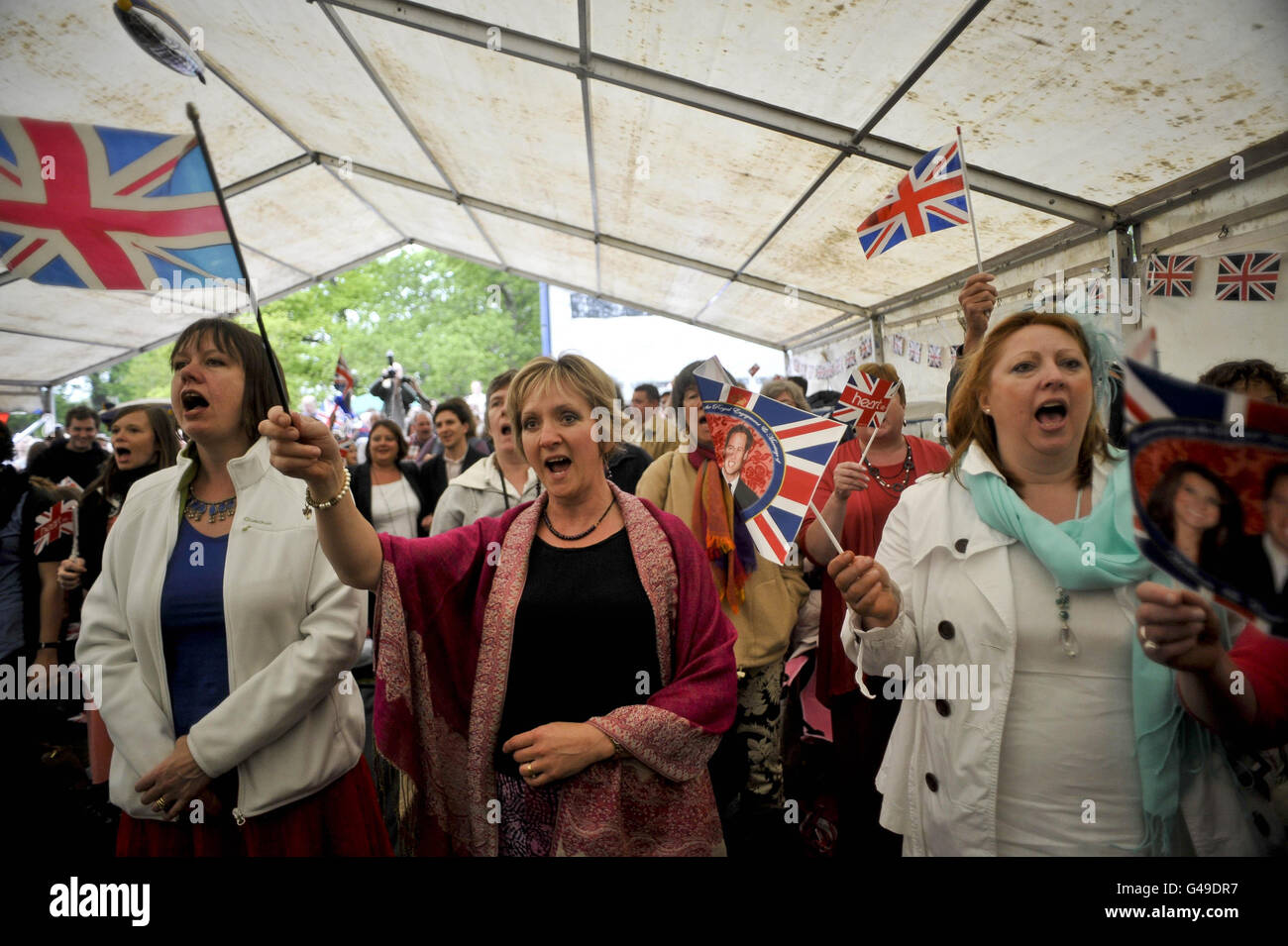 People wave flags and sing the National anthem as they watch the live ...