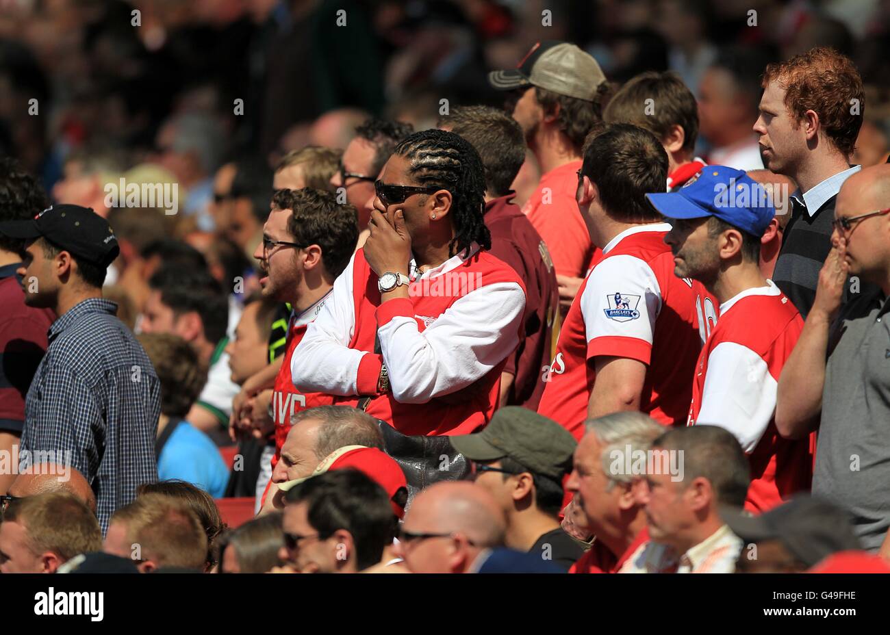 Arsenal fans look on anxiously from the stands hi-res stock photography ...