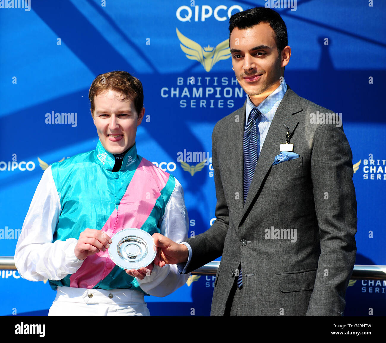 Frankel's Jockey Tom Queally (left) is presented with a trophy after ...