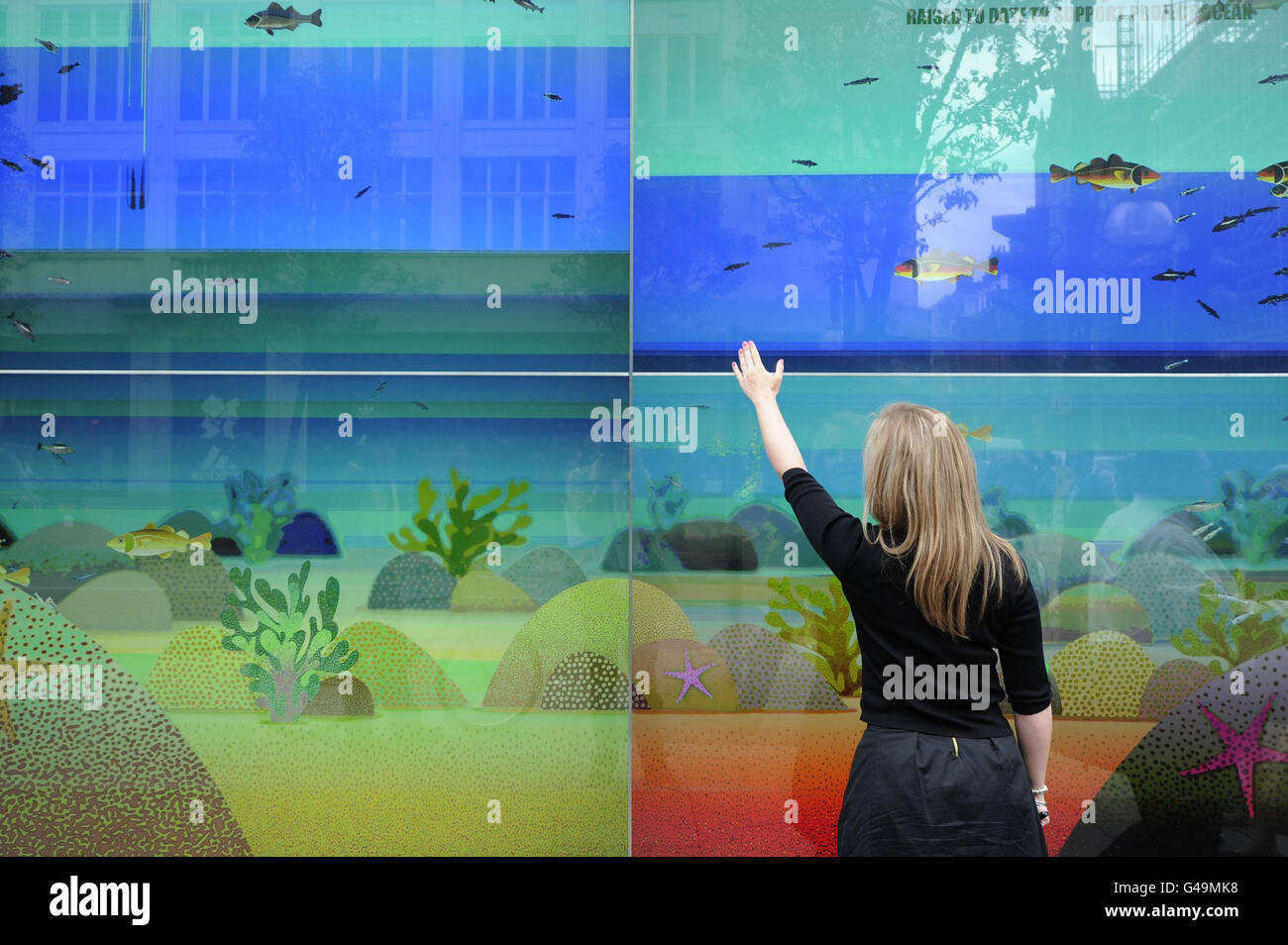 A woman touches the interactive fundraising window outside Selfridges ...