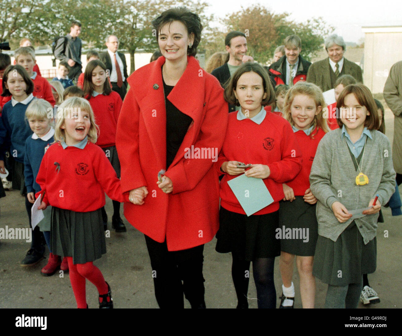 Cherie Blair, wife of the Prime Minister Tony Blair, holds the hand of ...