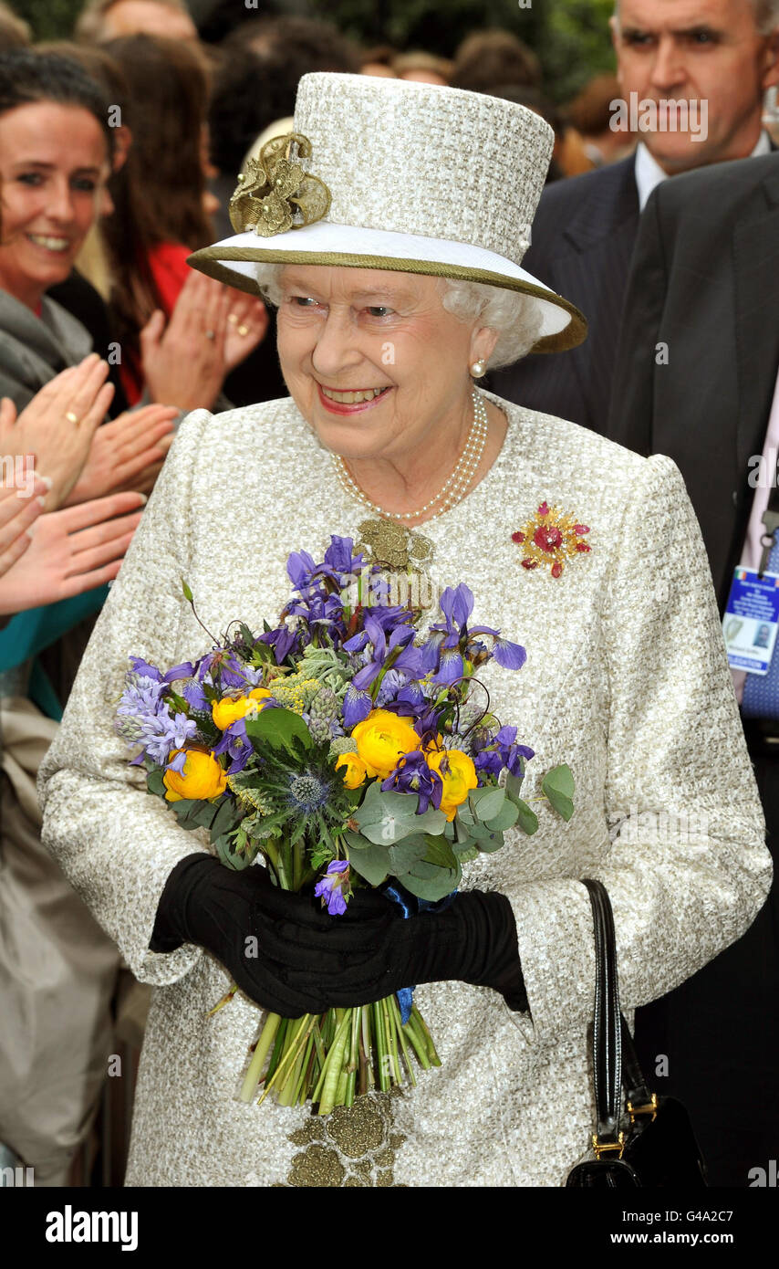 Britain's Queen Elizabeth II smiles as she is greeted by a large group ...