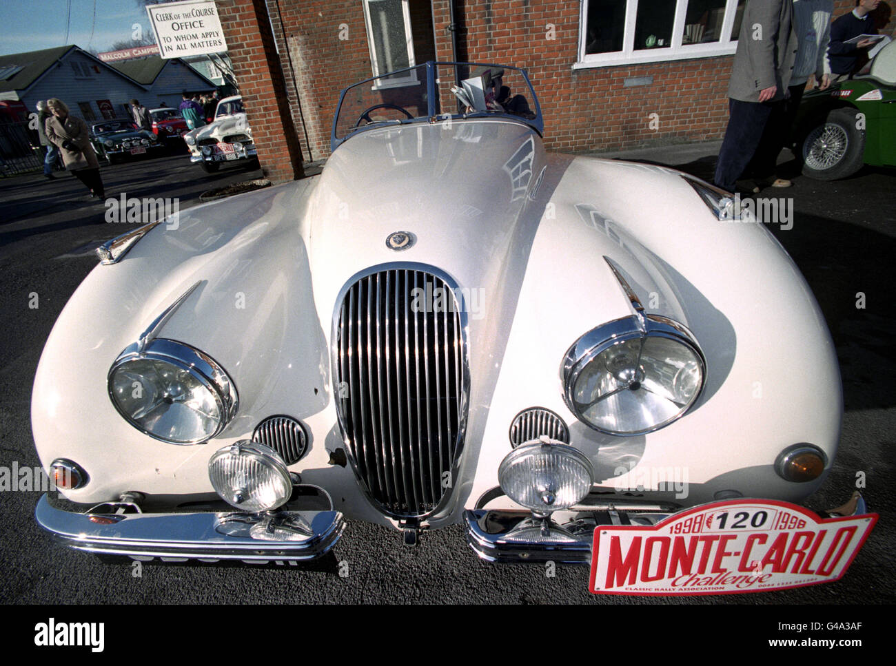 Co-driver Adrian Biles checks his route as he sits in his 1950 Jaguar ...