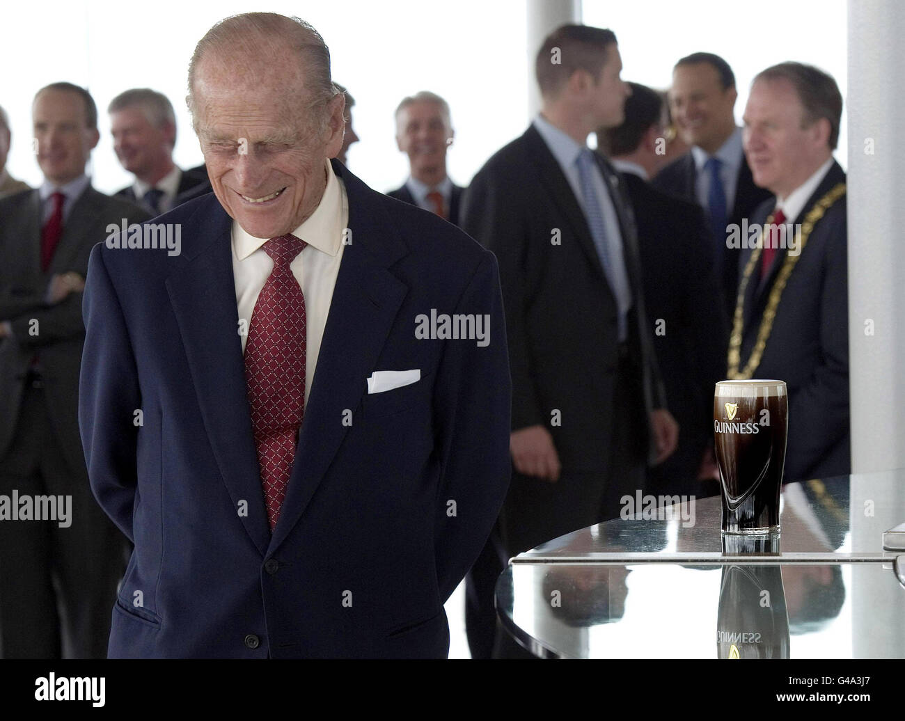 The Duke of Edinburgh laughs after seeing a pint of Guinness poured at ...