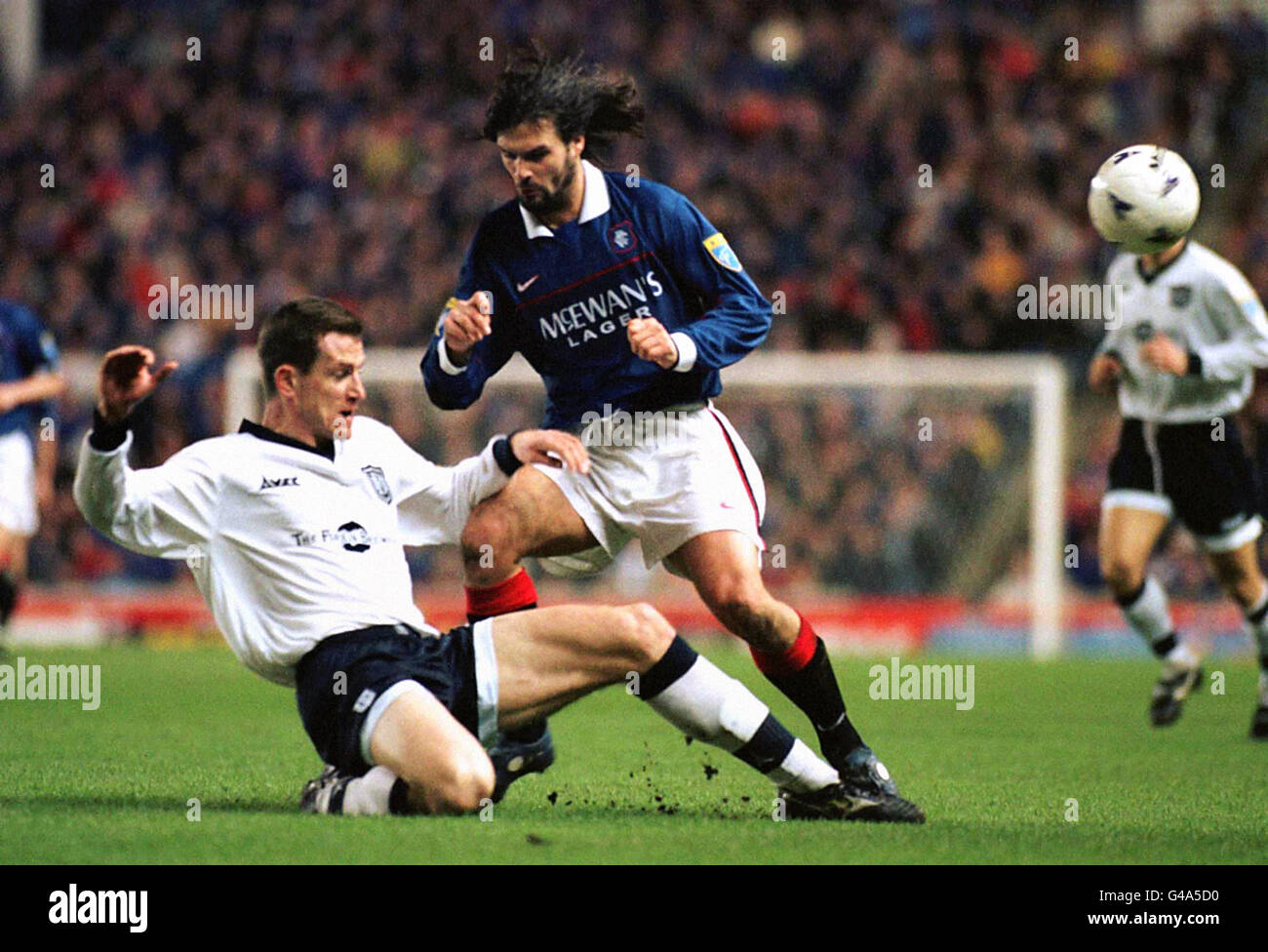 Dundee's Brian Irvine (left) clears the ball from Rangers' Marco Negri ...