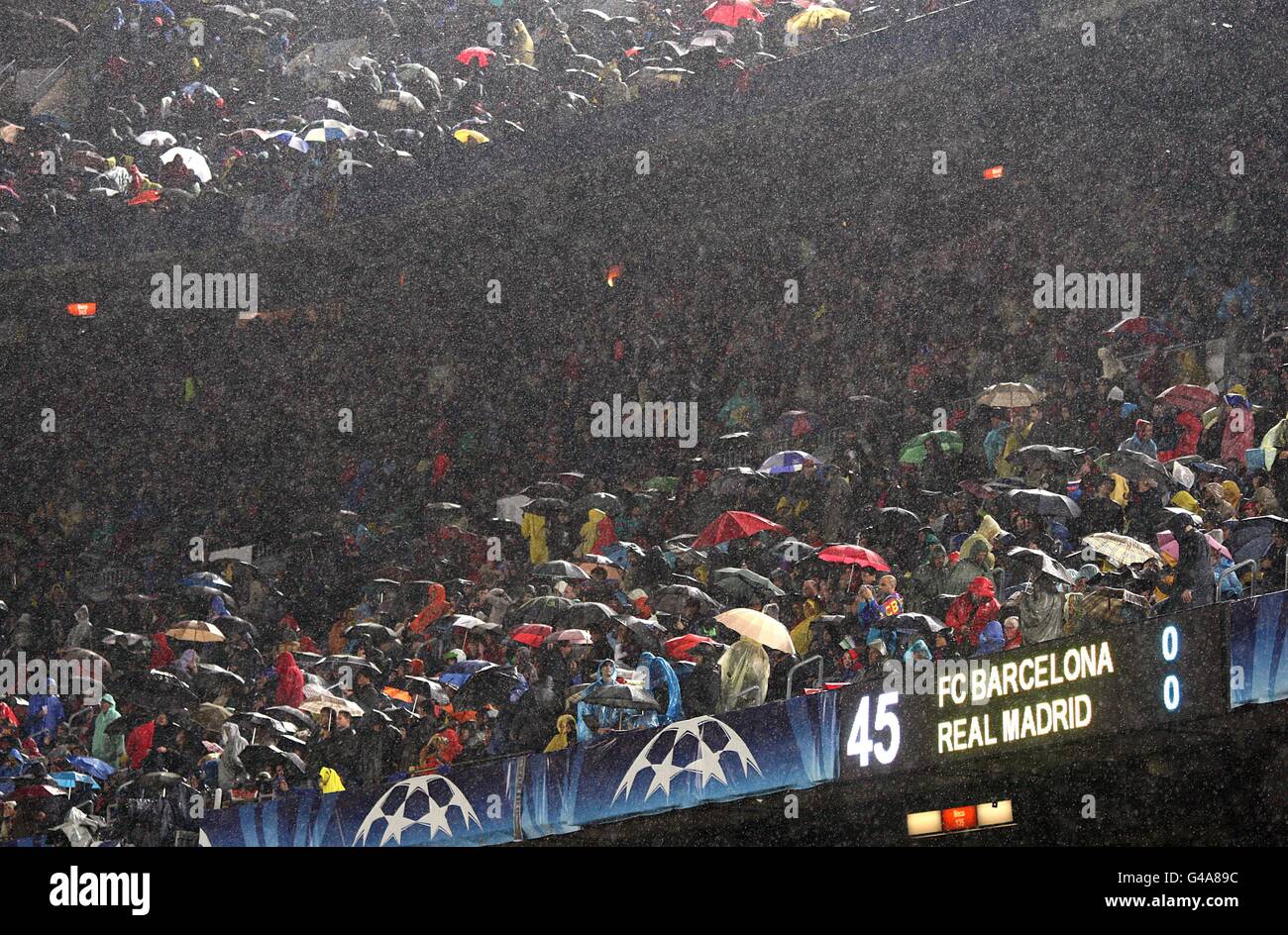 Fans shield themselves from the pouring rain with umbrella's in the ...