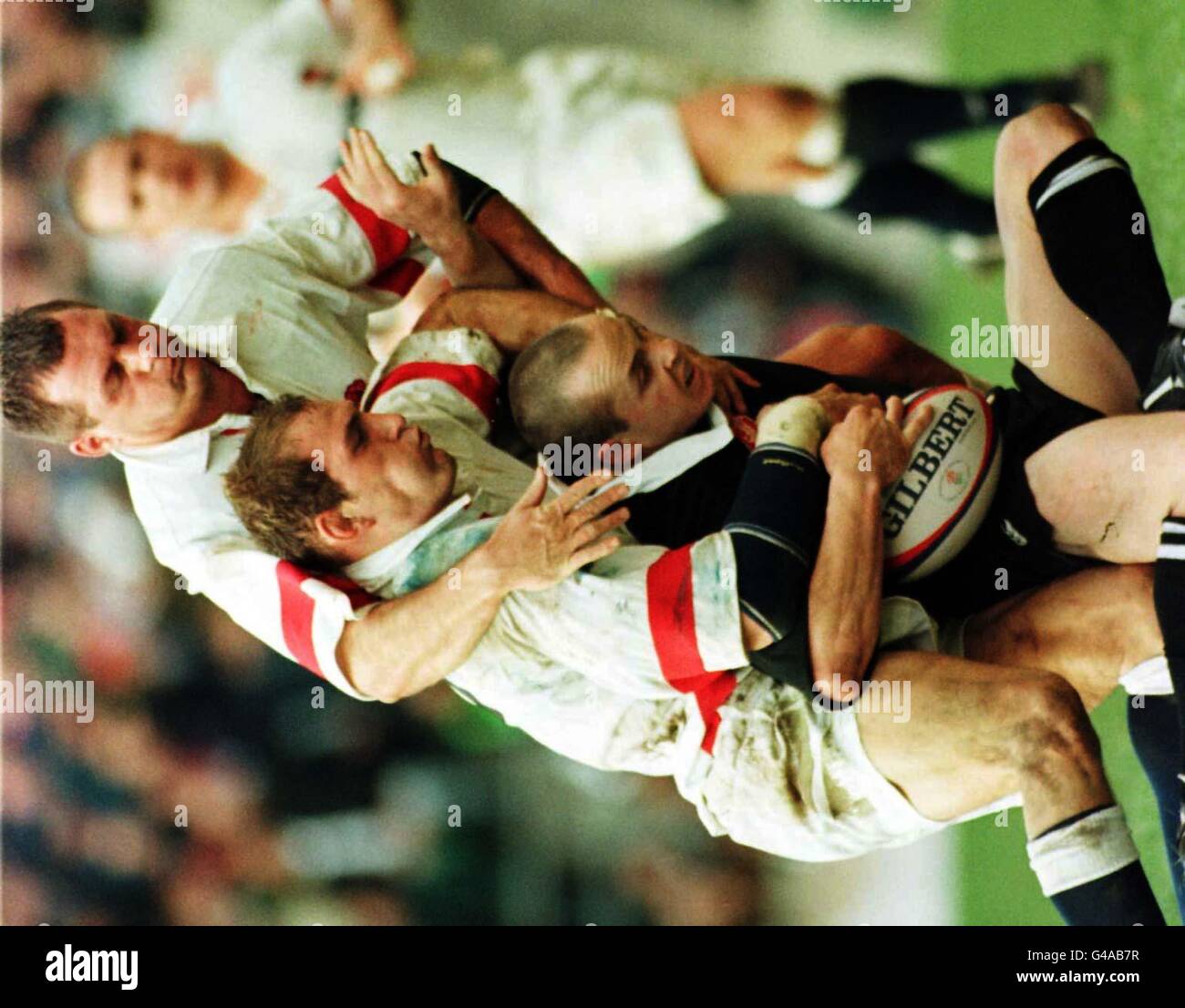 New Zealand's Josh Kronfeld is pounced on by the England forwards ...