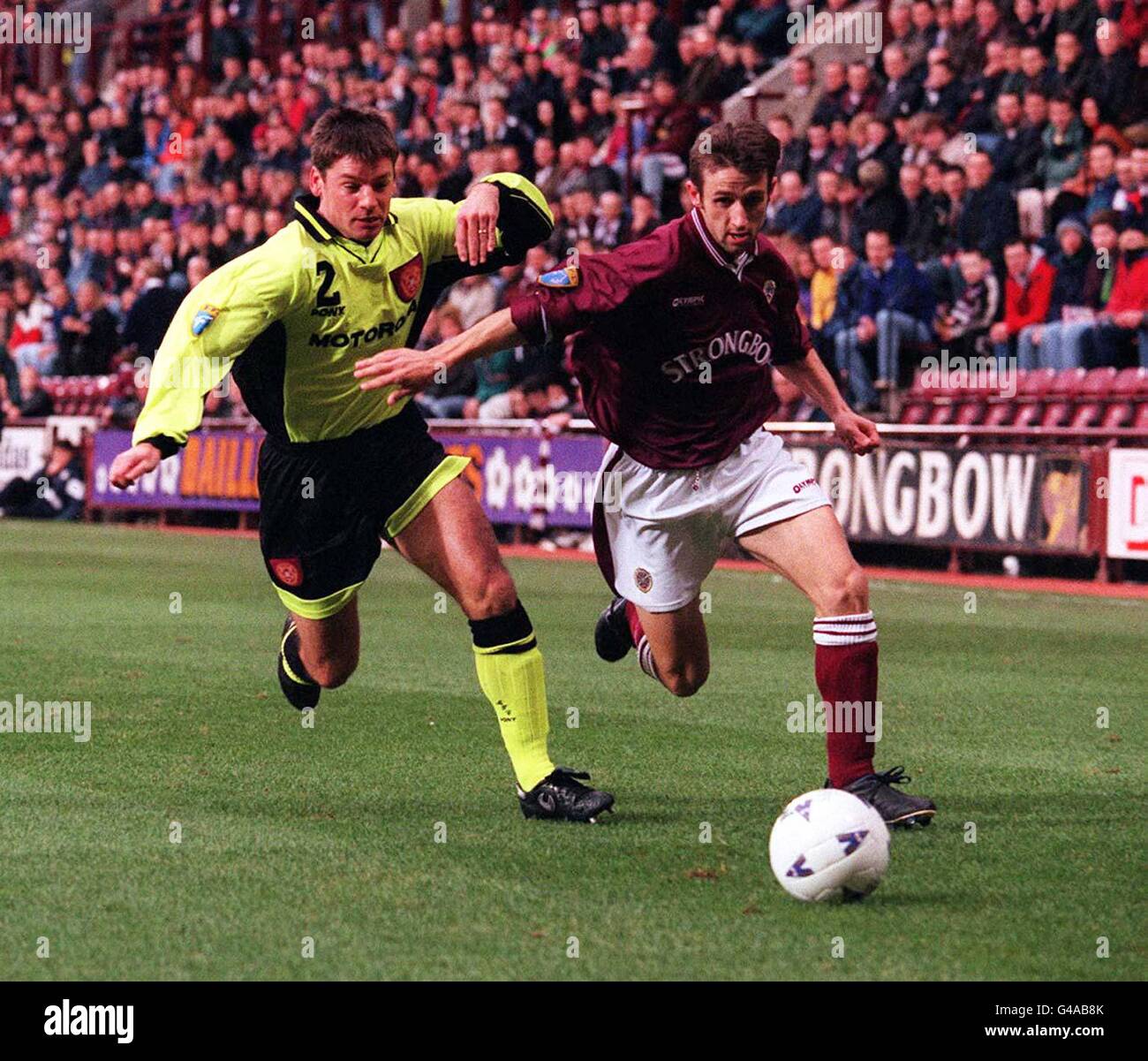 Hearts' Neil McCann with the ball skins Motherwell's Eddie May (left ...