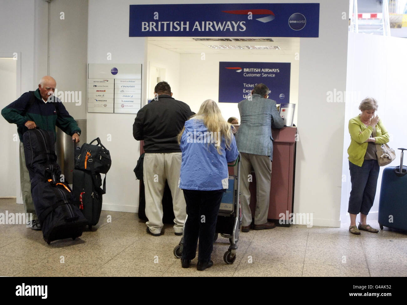 Passengers queue at an information desk at Glasgow Airport in Scotland ...