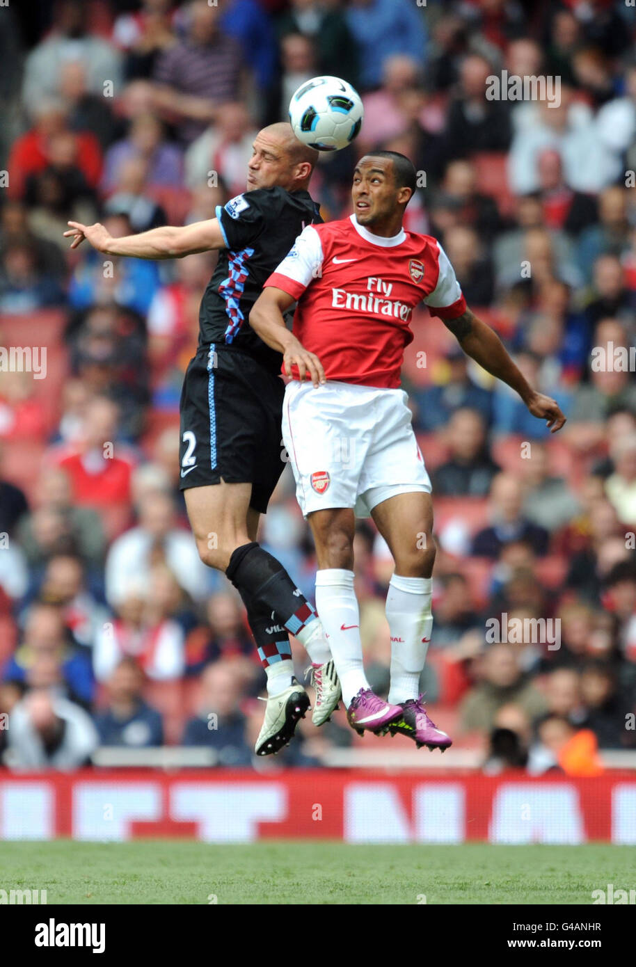 Arsenal's Theo Walcott and Villa's Luke Young compete for a header ...