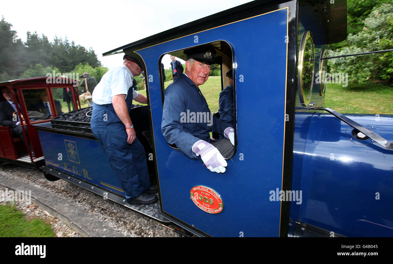 The Prince of Wales drives a steam train during a visit to Exbury ...