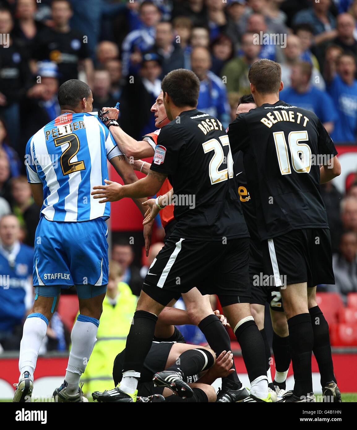 Referee Steve Tanner holds back Huddersfield Town's Lee Peltier before ...