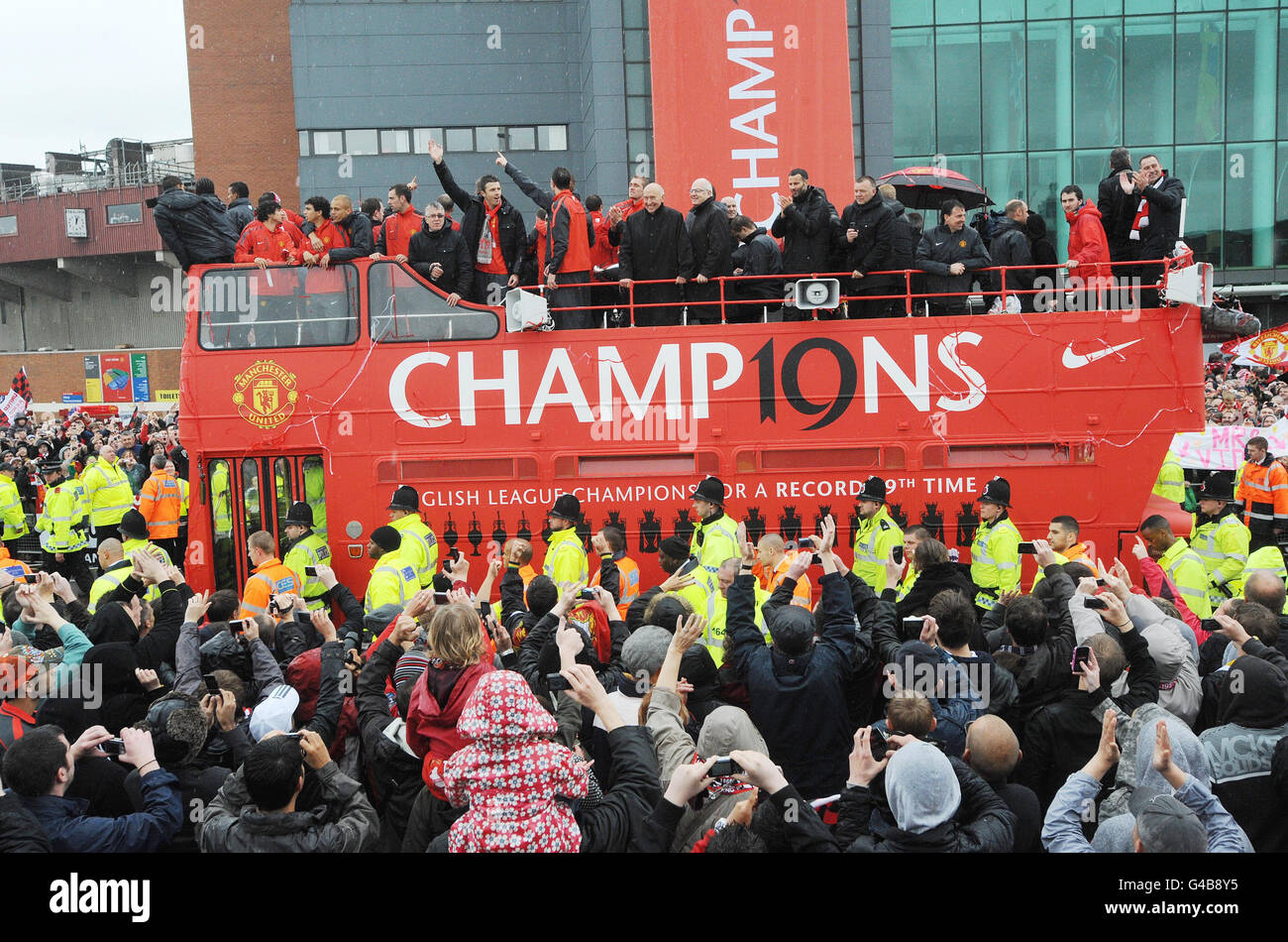 The Manchester United team wave to fans on an open top bus during the ...