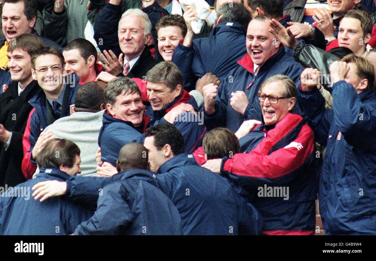 Arsenal manager Arsen Wenger (centre with hand on shoulder) celebrates ...