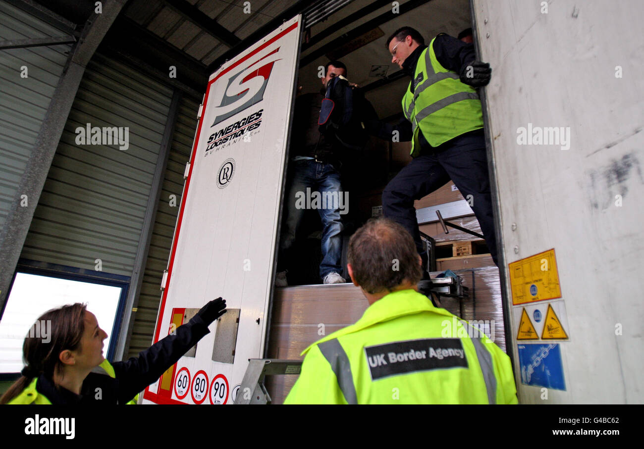 A stowaway passenger climbs down from a lorry trailer helped by UK ...