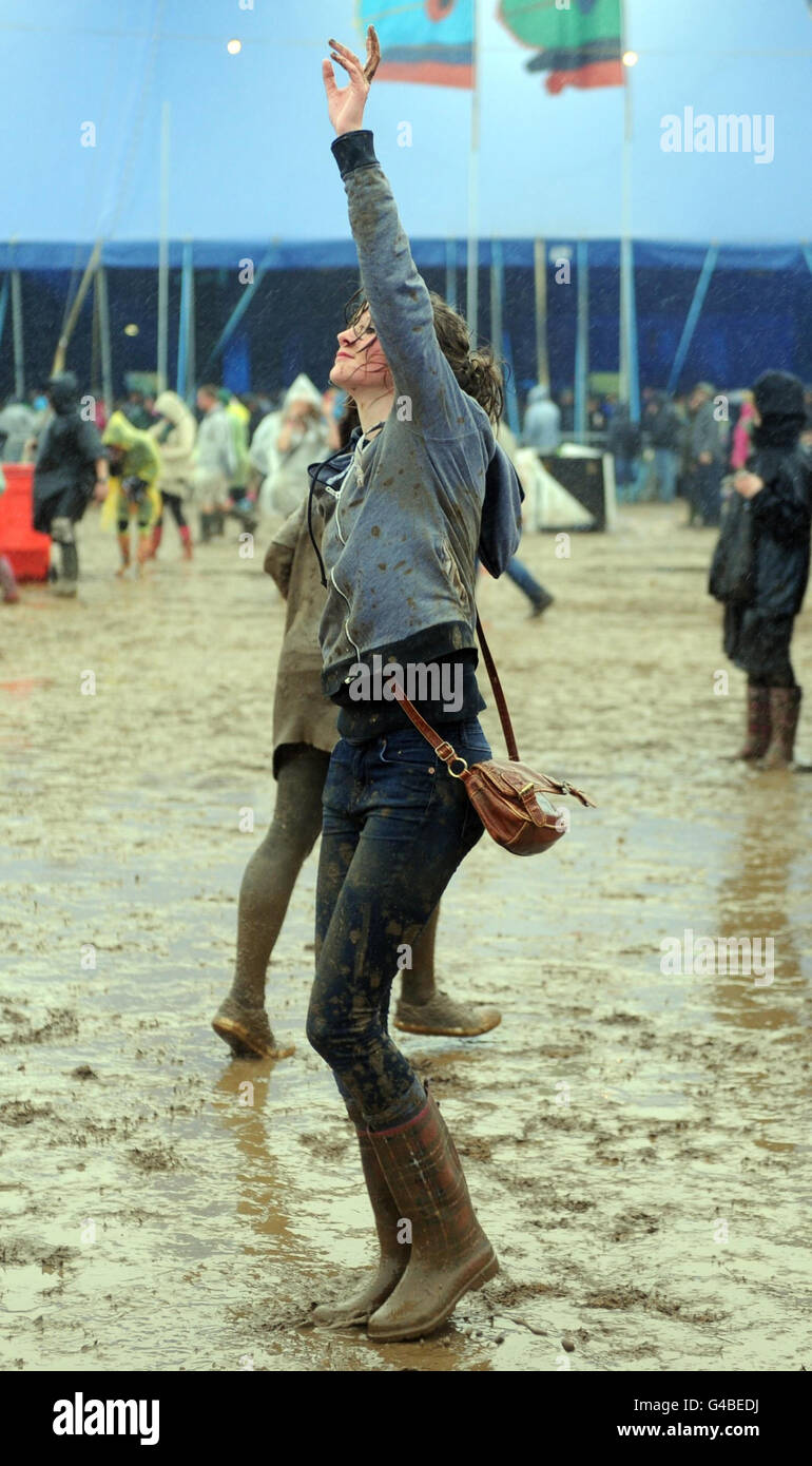 Festival goers dance in the mud during the final day of the Isle of ...