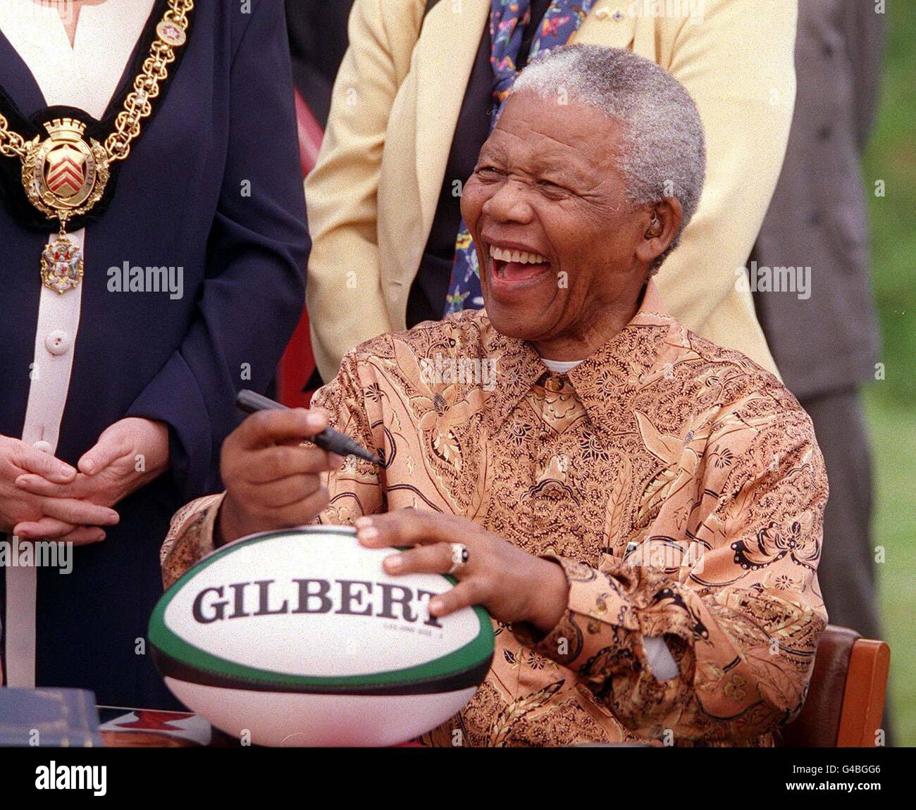 South African President Nelson Mandela signs a rugby ball during a ...