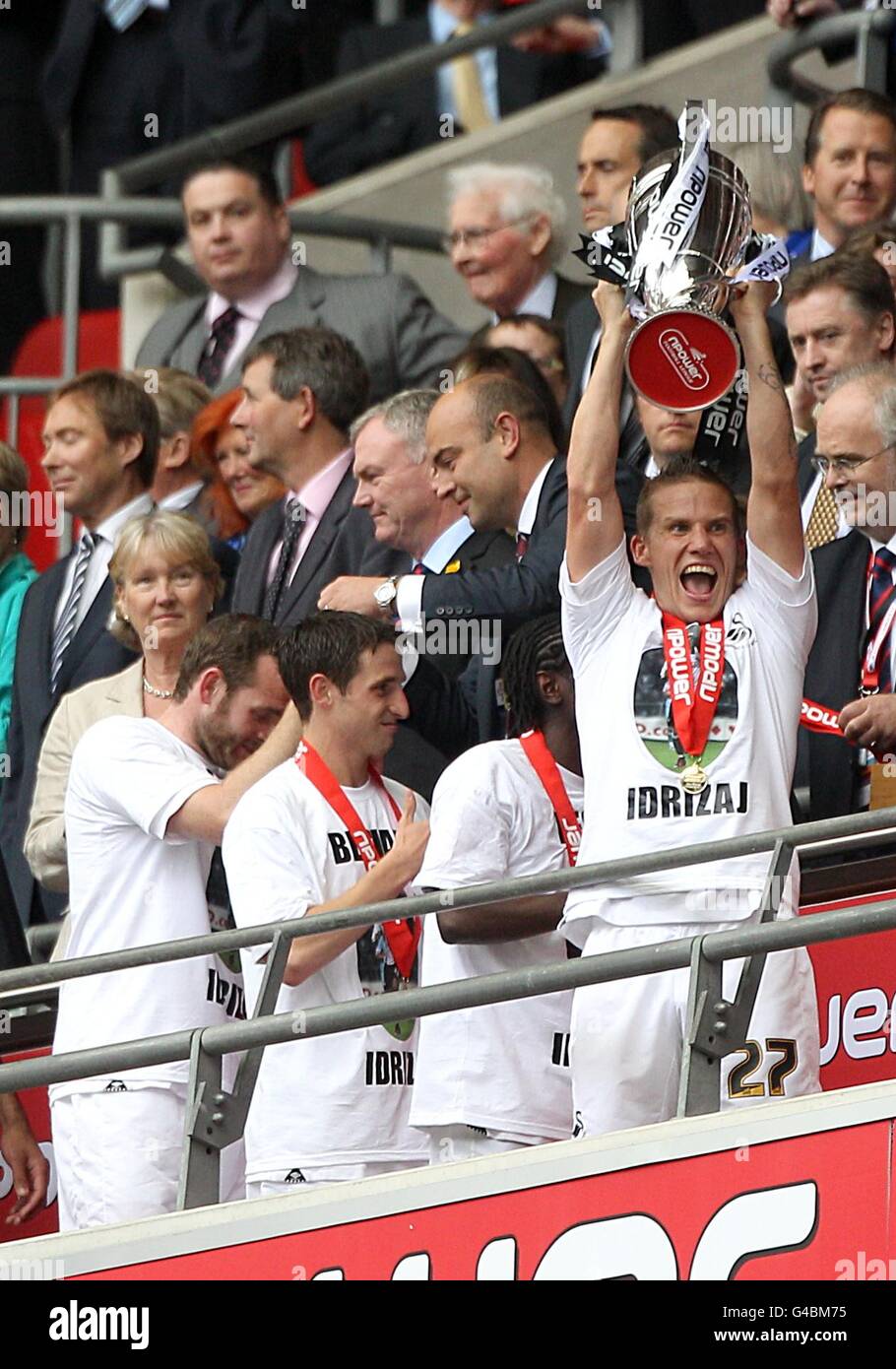 Swansea City's Mark Gower holds the Championship Play Off Trophy aloft ...