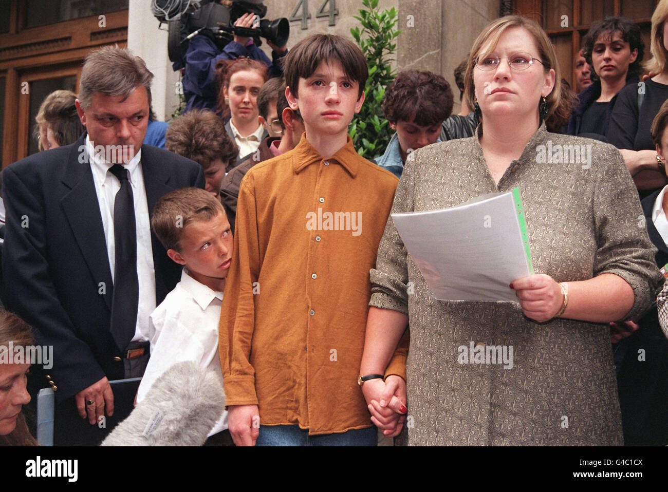 Helen Rickard holds the hand of Sam Shortis (12),as bereaved families ...