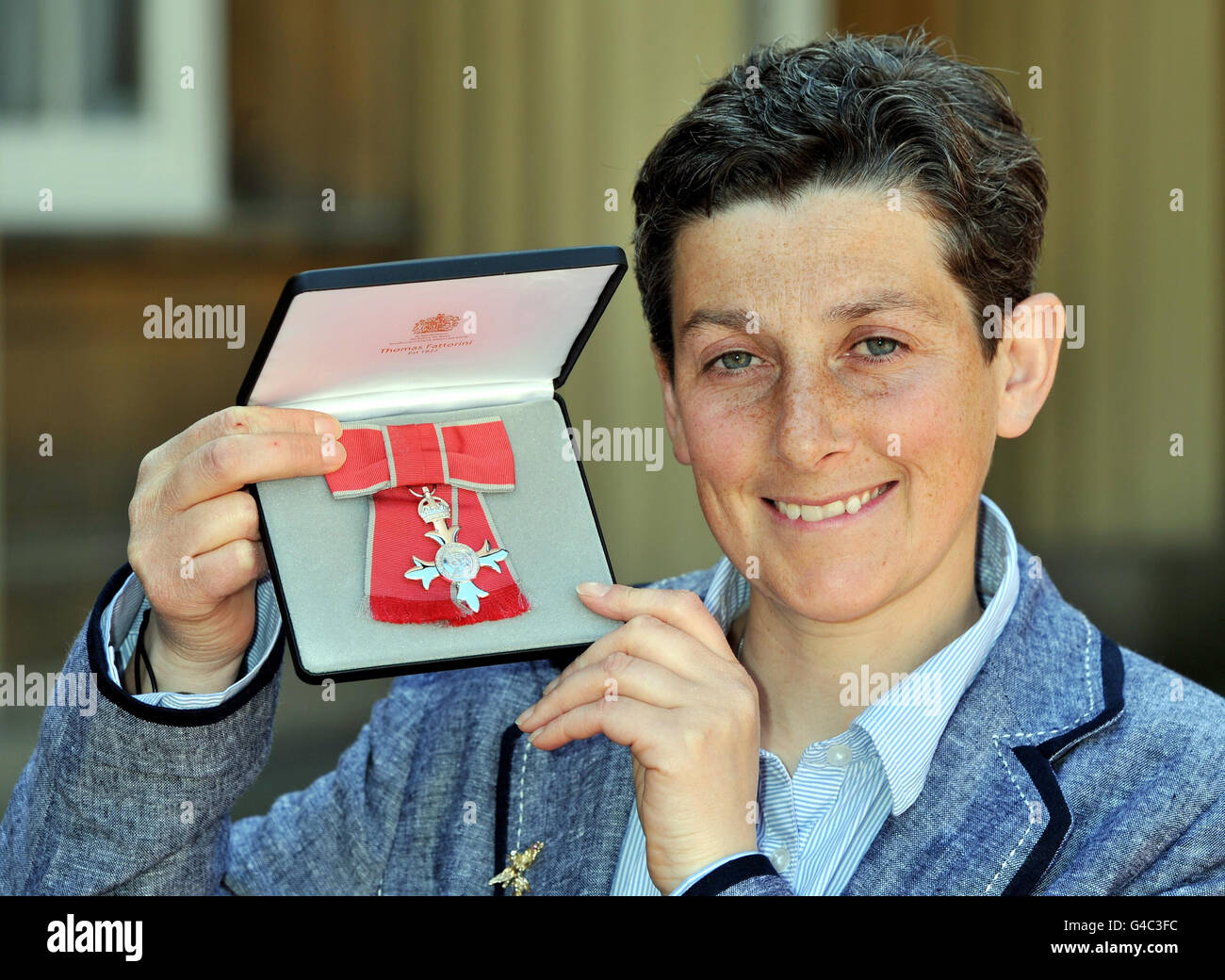 Holds his mbe following an investiture ceremony at buckingham palace hi ...