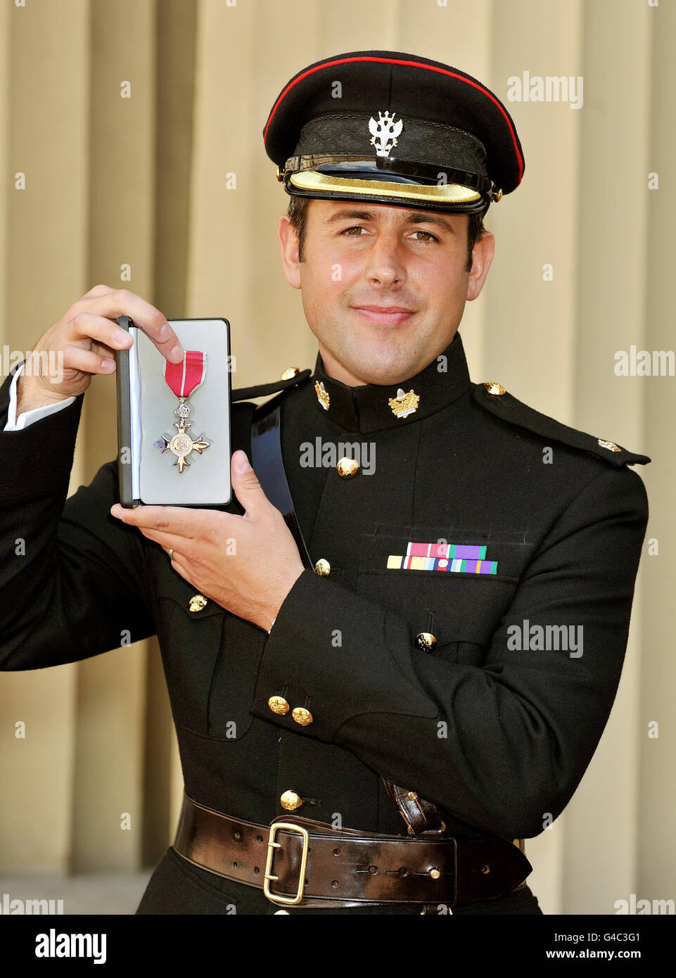 Holds his mbe following an investiture ceremony at buckingham palace hi ...