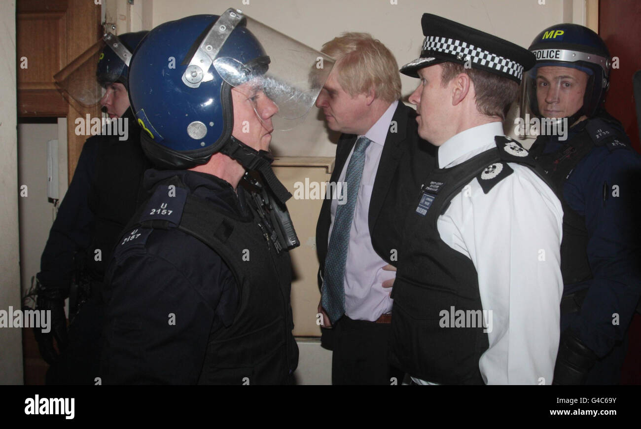 Boris Johnson accompanies police officers during a dawn raid at a ...