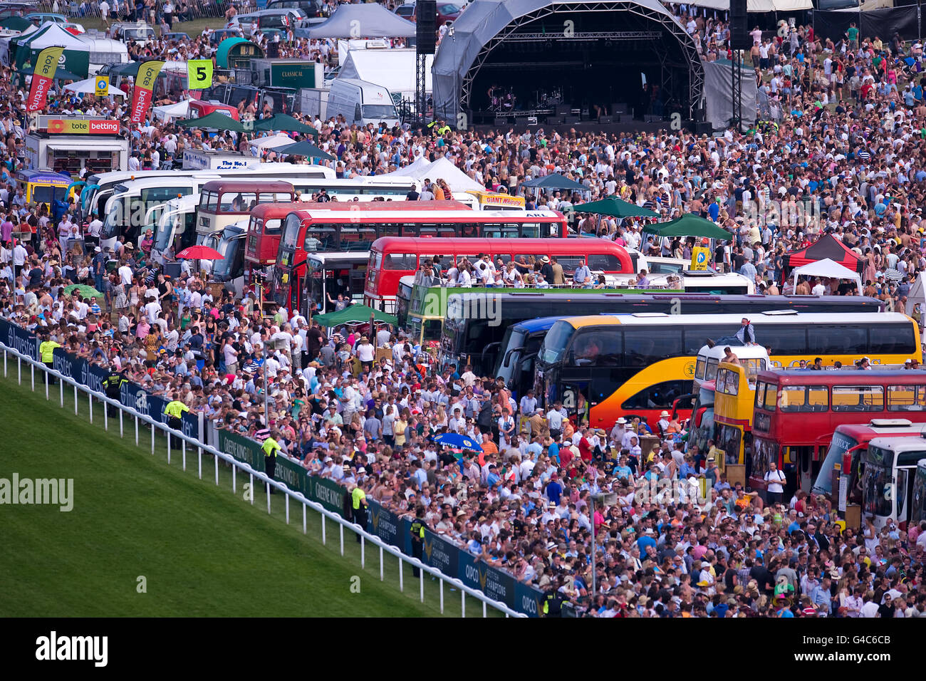 Racegoers gather around double decker buses on the infield at Epsom ...
