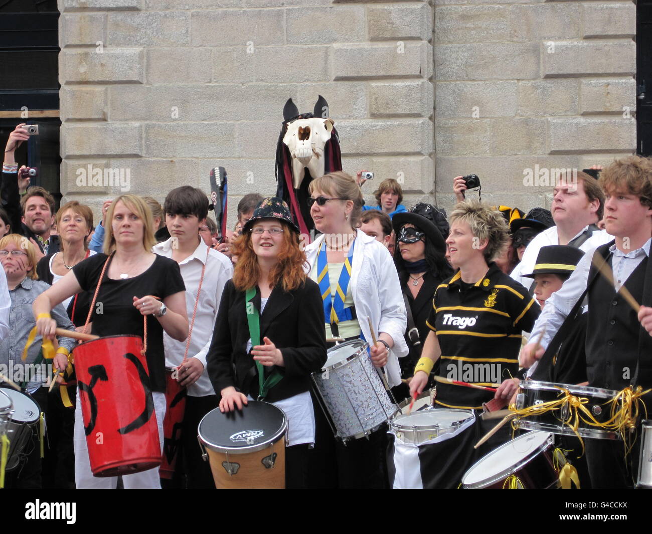 Drummers join Queen drummer Roger Taylor (not seen) on a march through ...