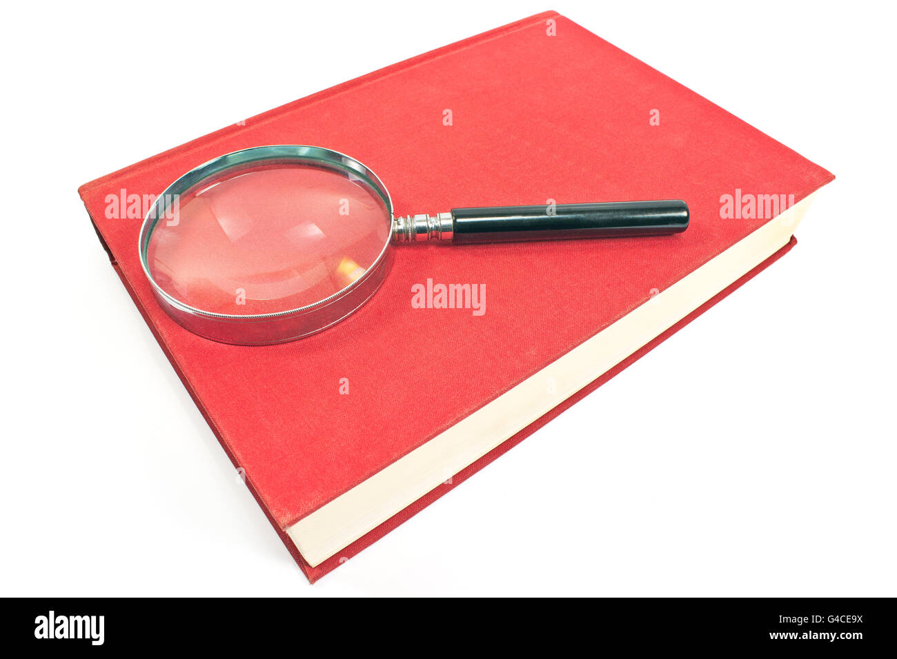 Antique magnifying glass on red book isolated on white Stock Photo - Alamy