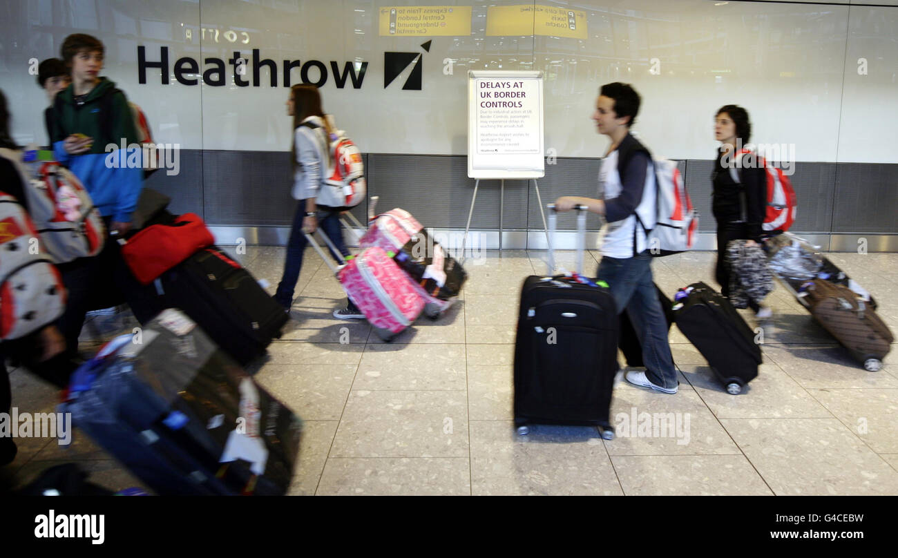 Passengers walk past an information sign in arrivals at Border Control ...