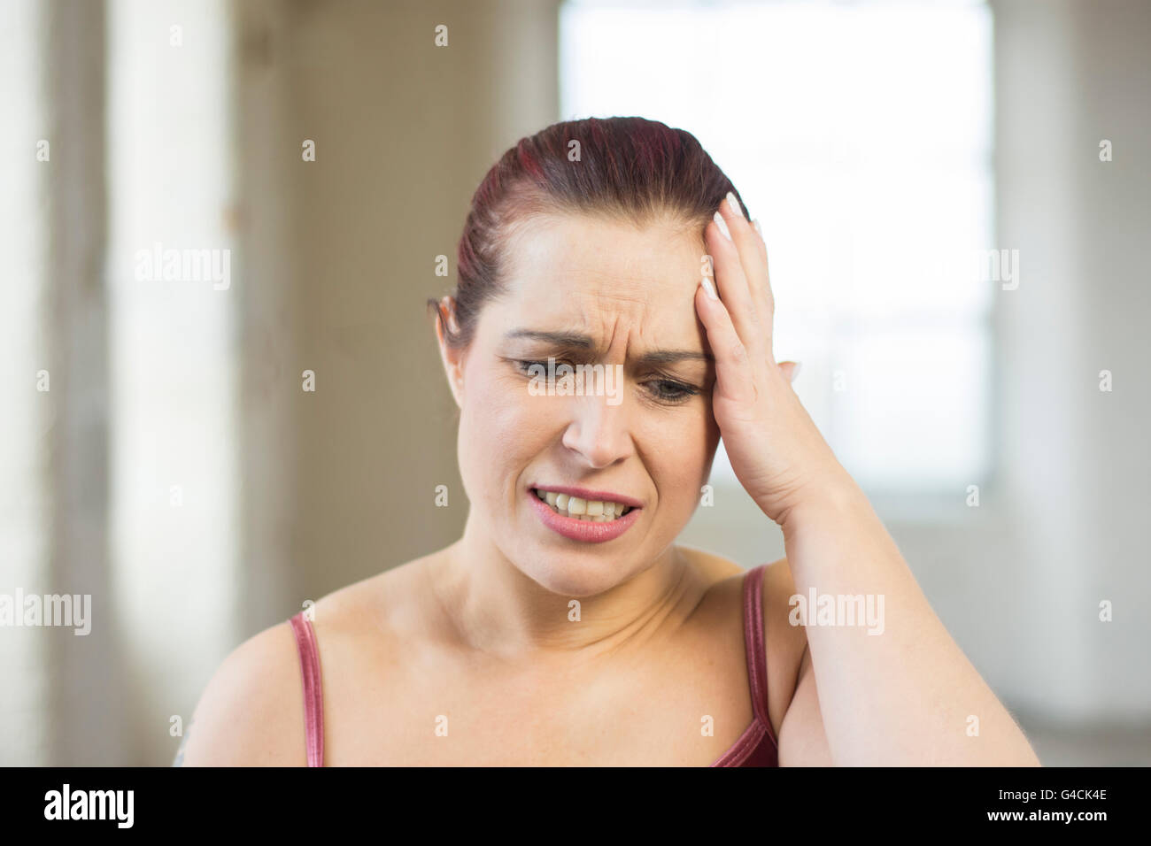 Stressed woman head in hands indoors Stock Photo - Alamy