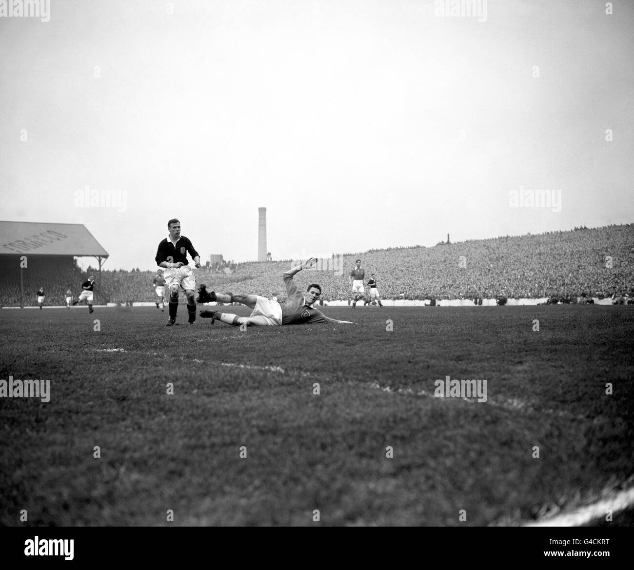 DANIEL, THE WALES CENTRE-HALF, HITS THE TURF INFRONT OF SCOTLAND CENTRE ...