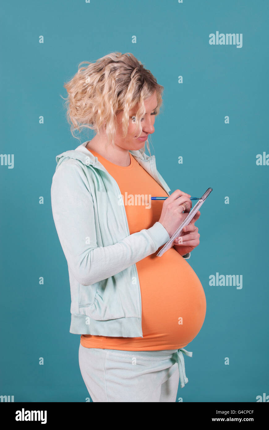 Pregnant woman writing notes Stock Photo - Alamy