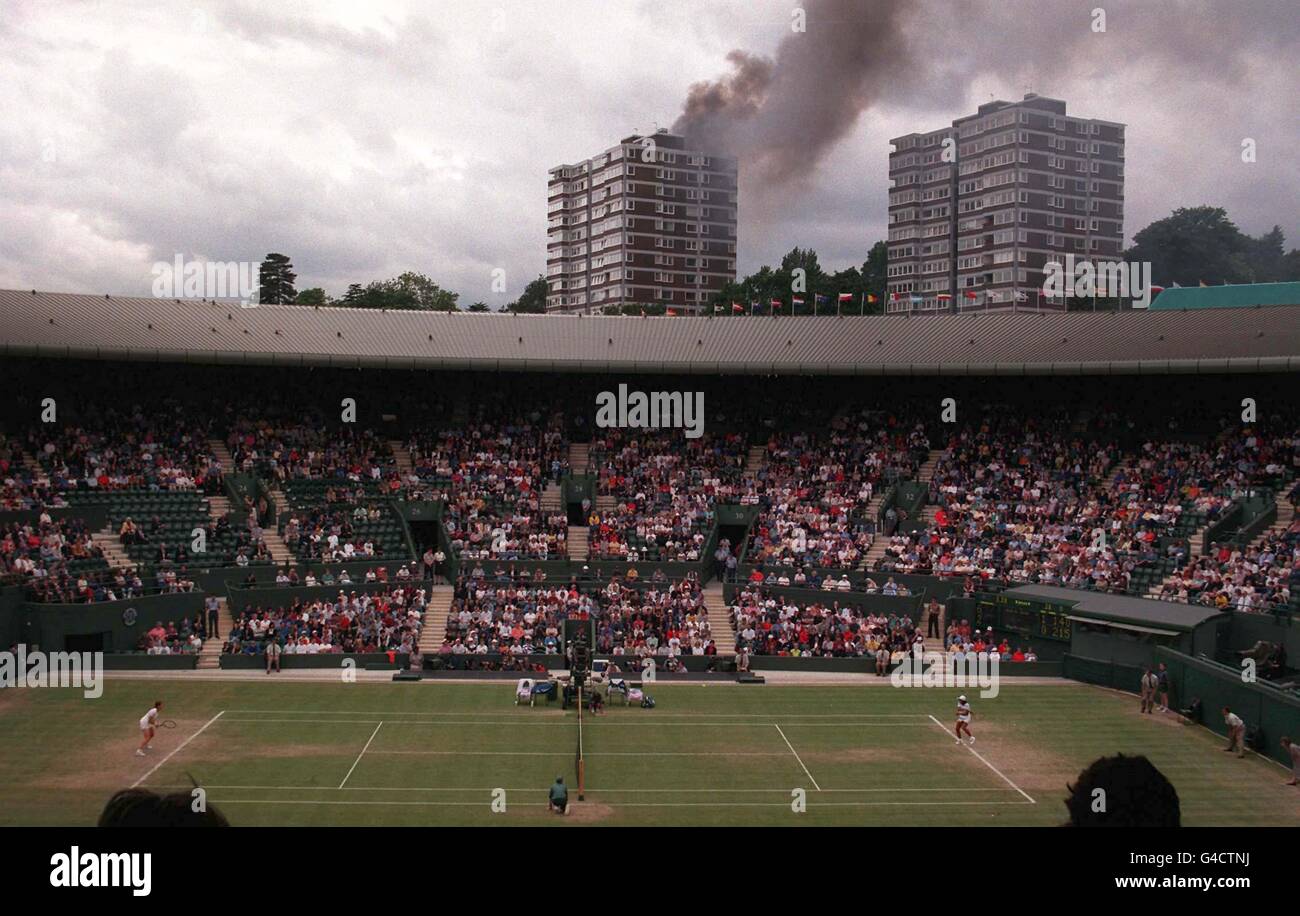 Smoke and flames billow from the top story of a block of flats on ...