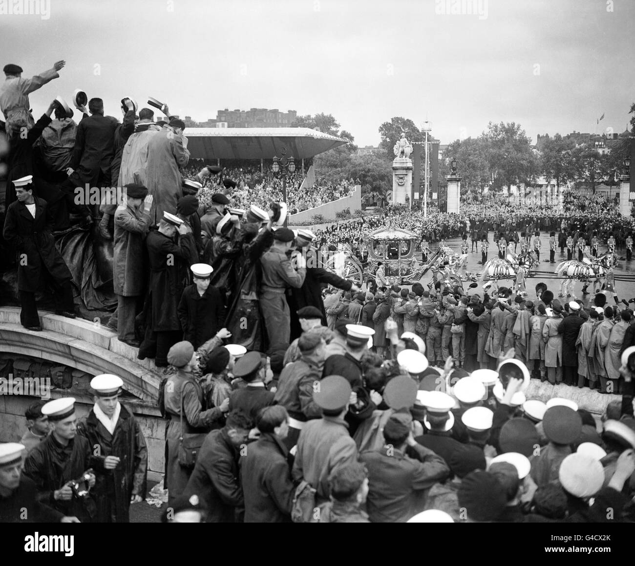 Crowds wave and cheer the newly crowned Queen Elizabeth II as she ...