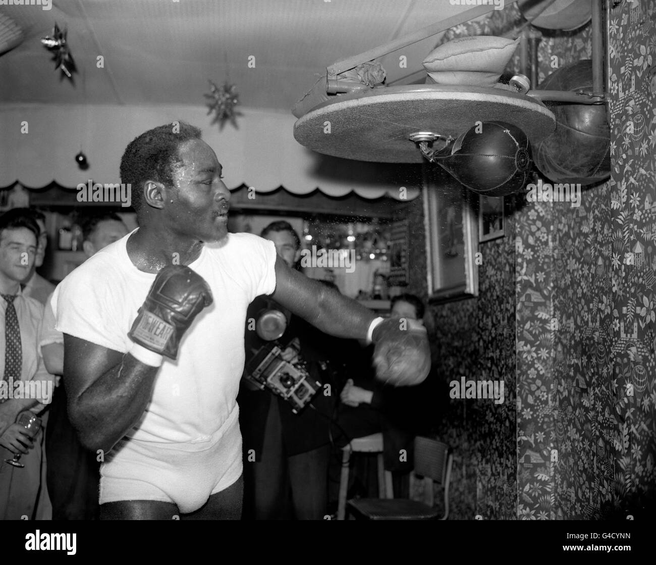 Former world heavyweight champion Ezzard Charles trains with the punch ...