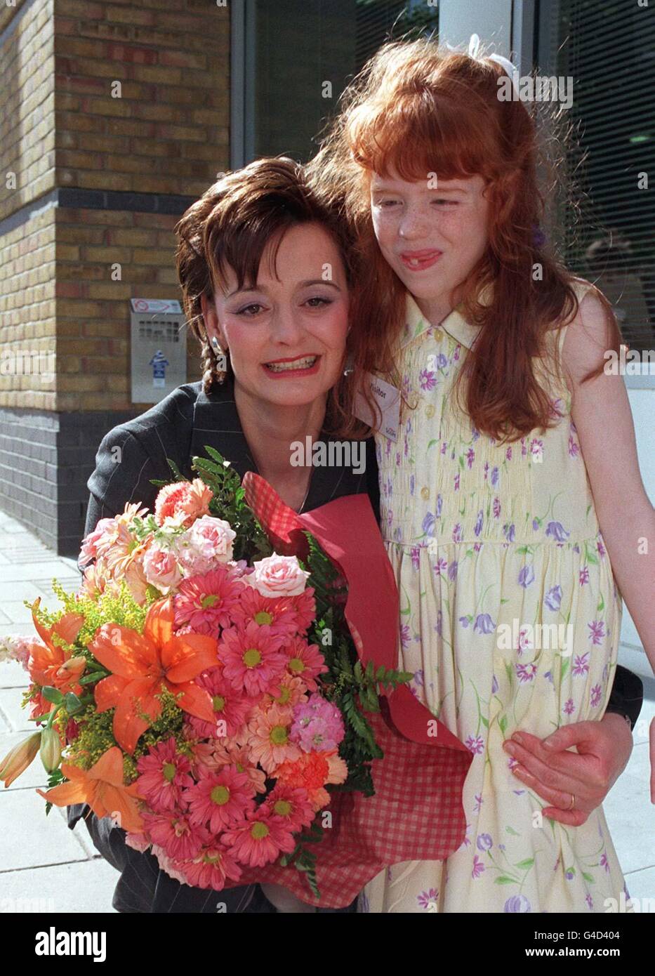 Prime Minister's wife Cherie Booth is presented with a bouquet by eight ...