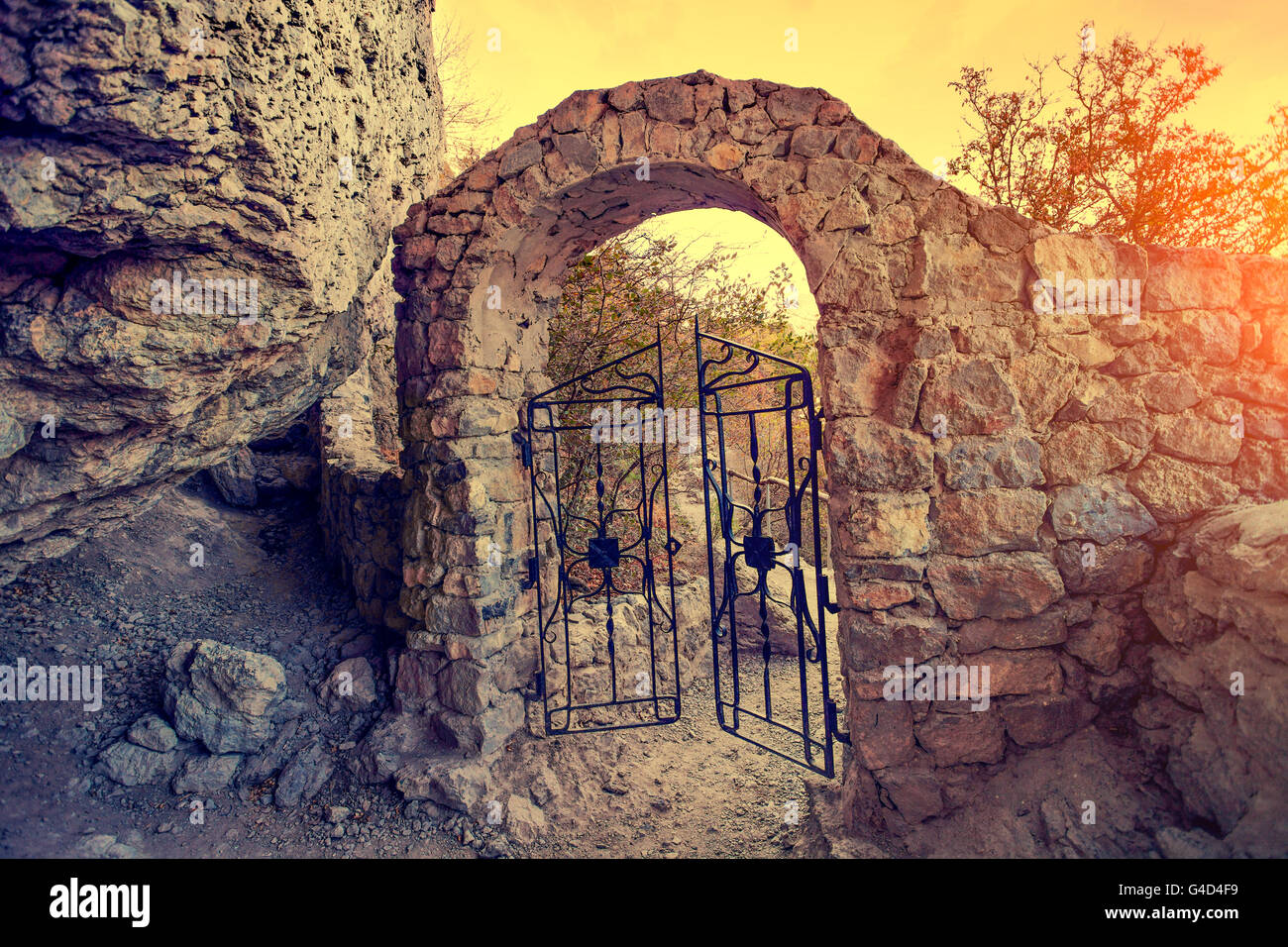 Open gate in rock at sunset Stock Photo - Alamy