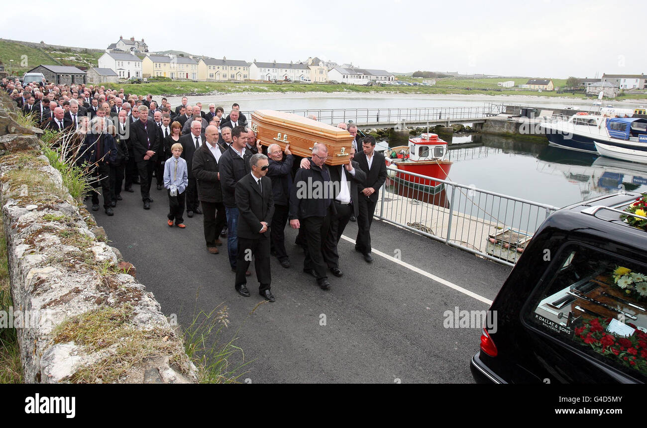 The coffin of Johnny Curry is carried passed Rathlin Island harbour ...